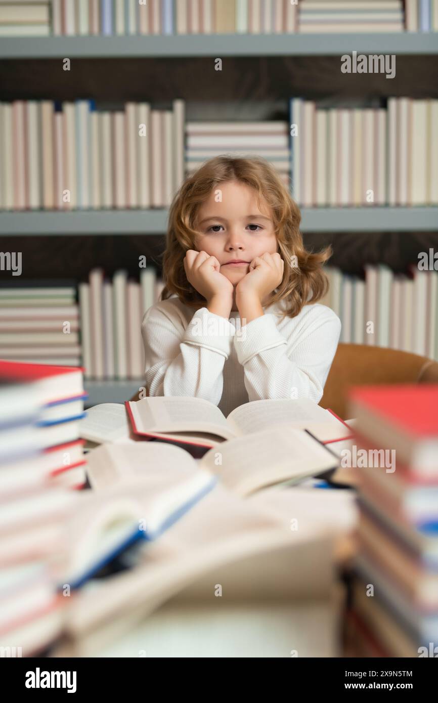 Back to school. School boy doing homework on desk in school library ...