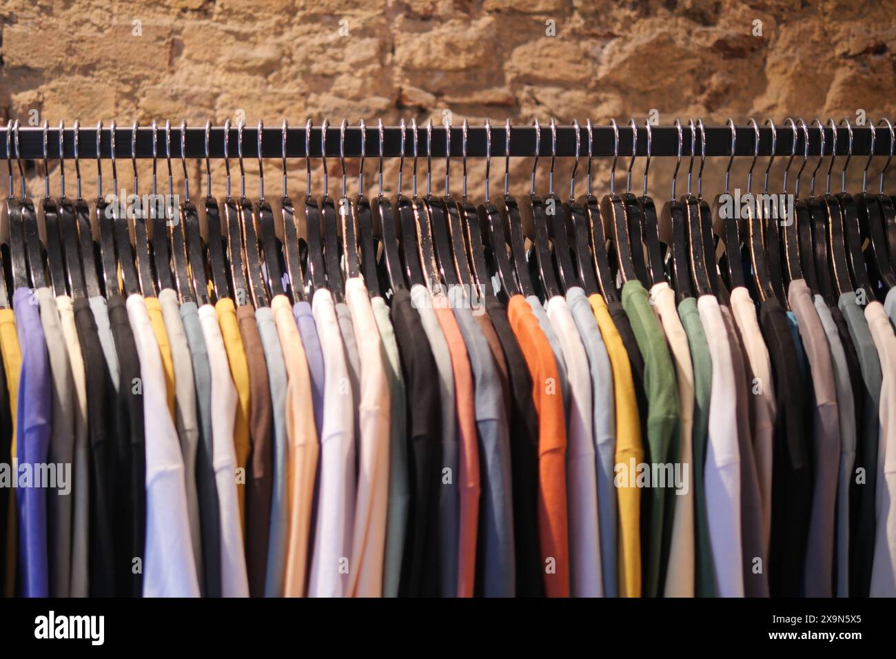 Colorful shirts displayed neatly on rack in clothing store, creating ...