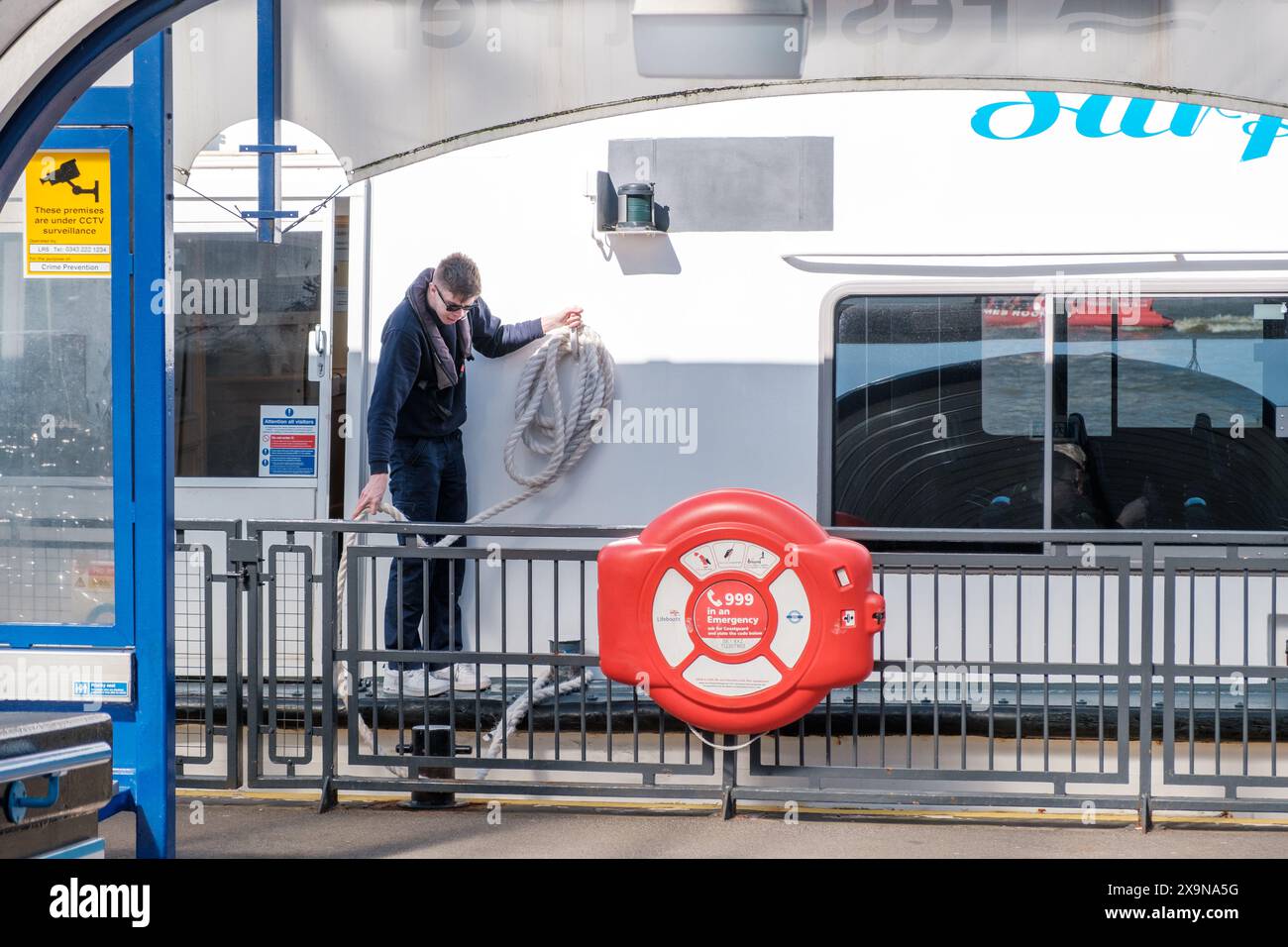 Man moors sightseeing boat with rope at Festival Pier, London Southbank ...