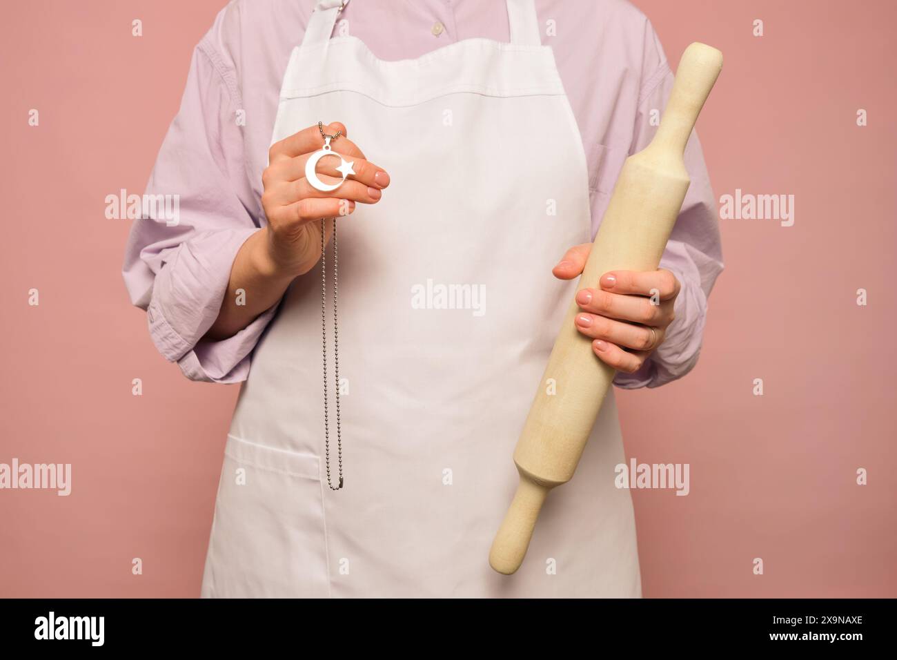Woman cook with islamic muslim symbol on studio pink background ...