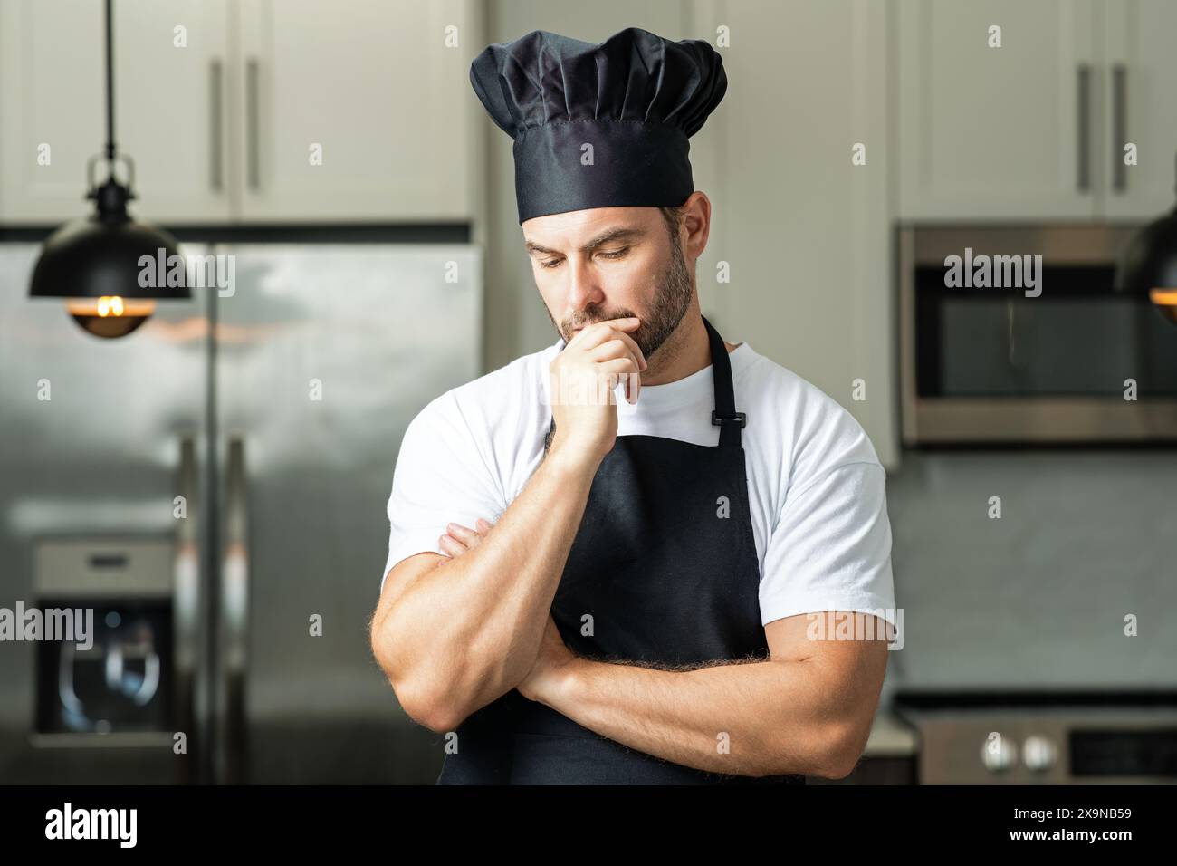 Handsome man chef in uniform cooking in the kitchen. Restaurant menu ...