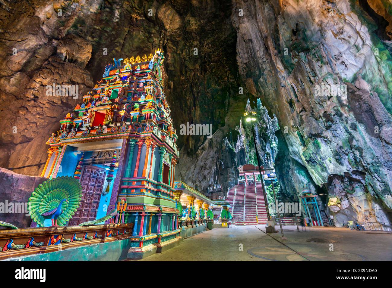 Visitors go through the tall cave entrance,down a flight of stairs,into ...