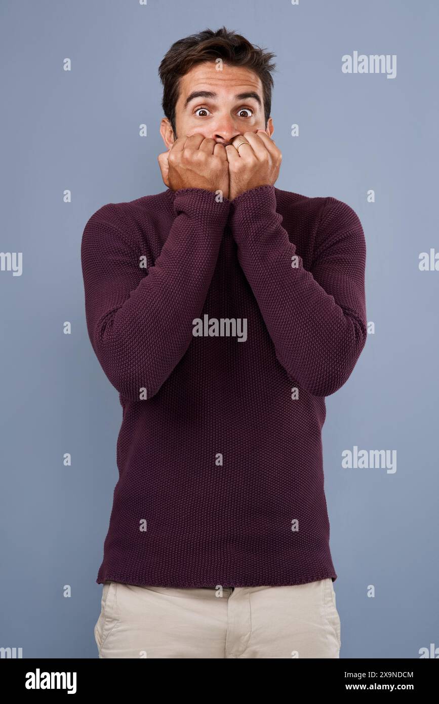 Portrait, afraid and phobia of man in studio, anxiety and biting of ...