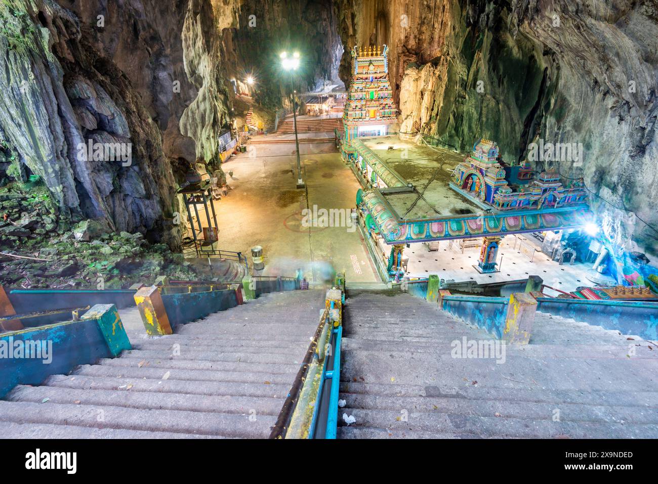 Visitors go through the tall cave entrance,down a flight of stairs,into ...