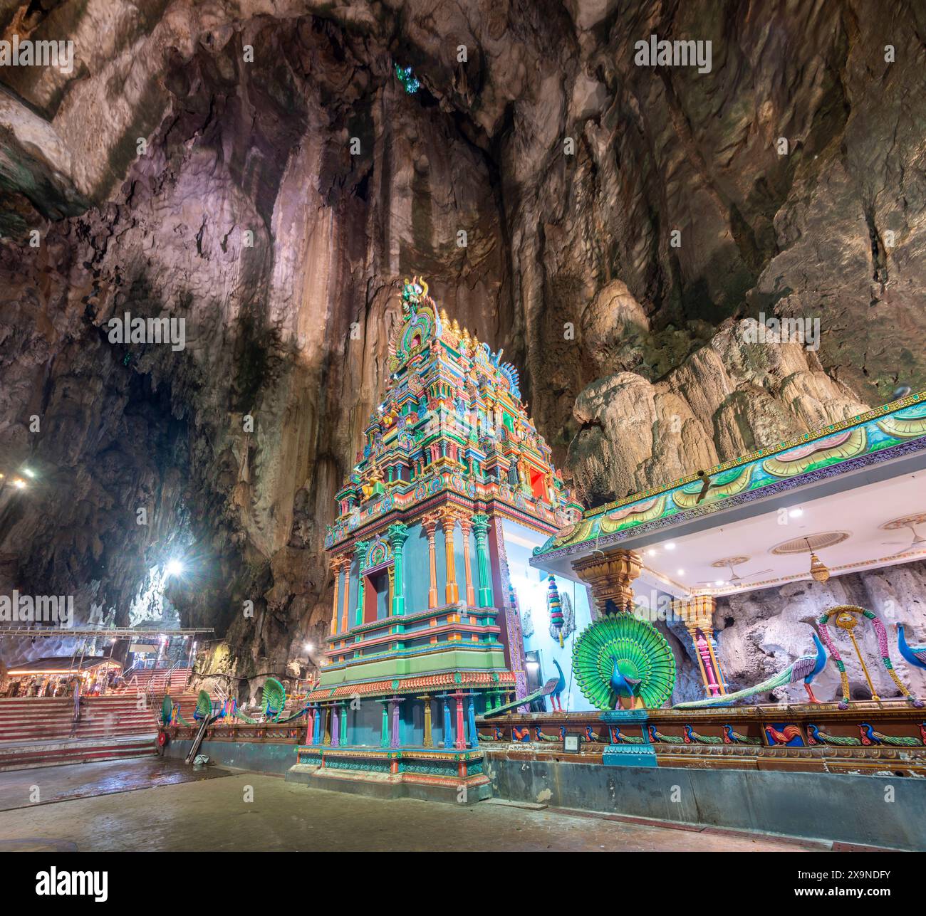 Visitors go through the tall cave entrance,down a flight of stairs,into ...