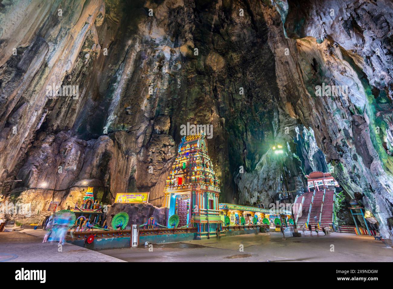Visitors go through the tall cave entrance,down a flight of stairs,into ...