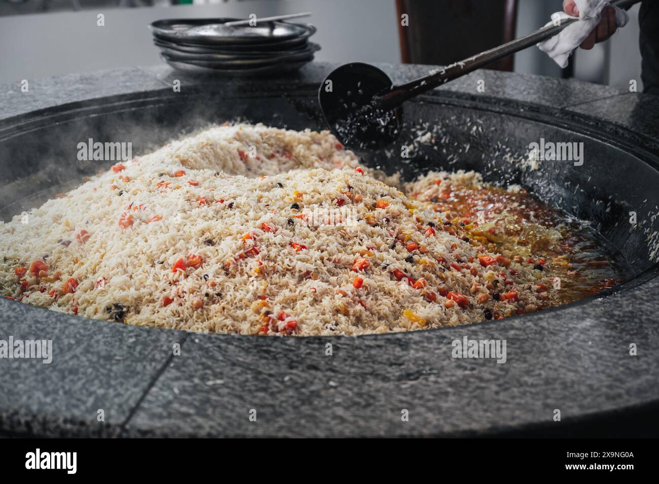 traditional oriental Uzbek pilaf in a large cauldron. Central Asian ...
