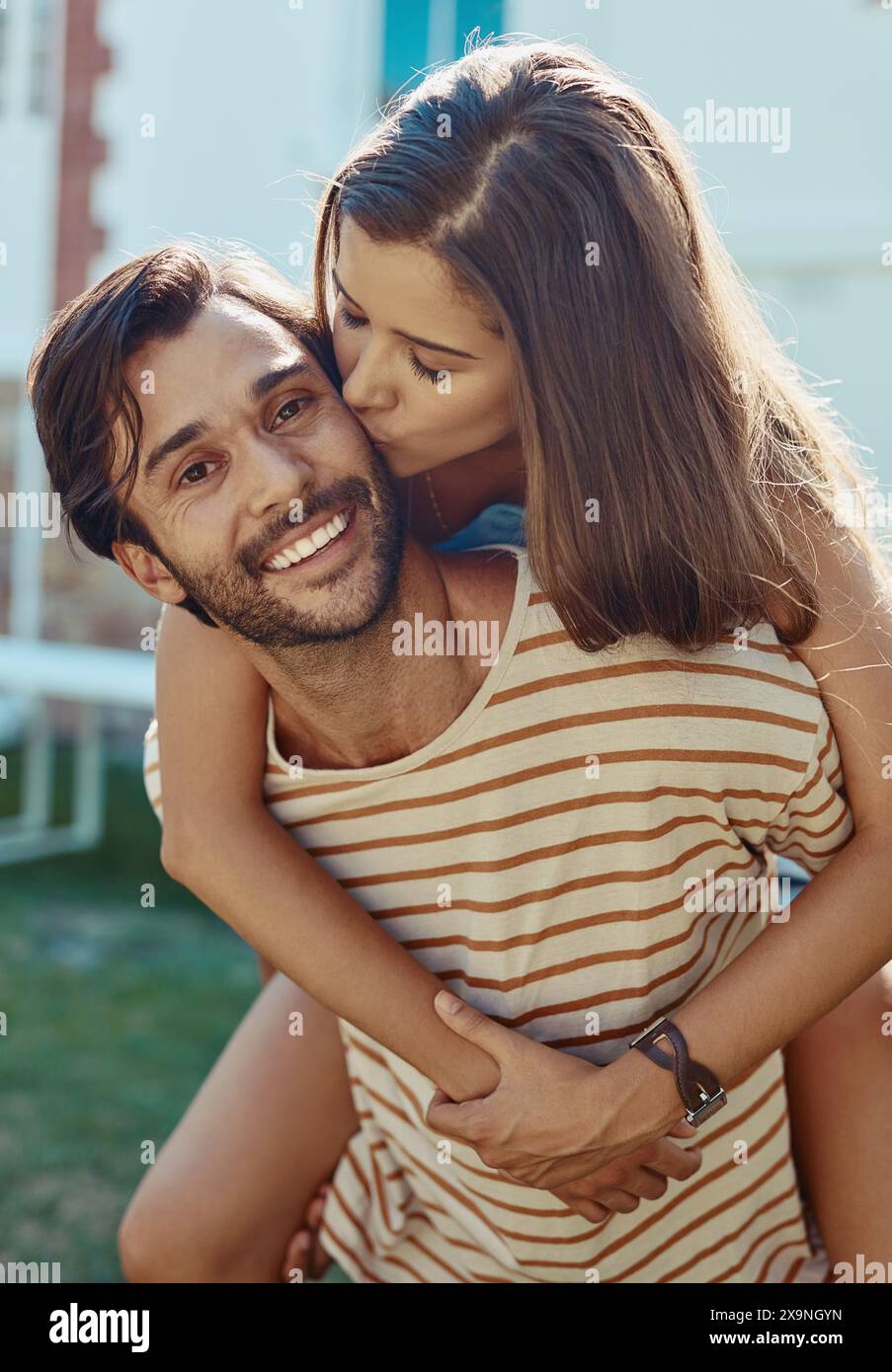 Couple, piggy back and kiss in portrait with sunshine, bonding and ...