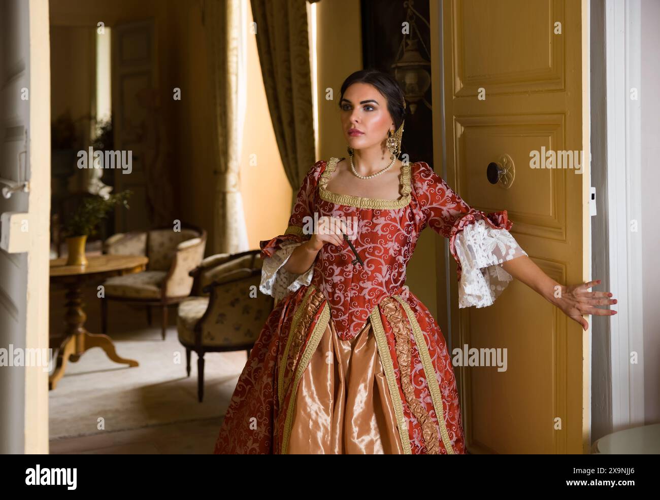 Beautiful woman in late renaissance costume posing between the open ...
