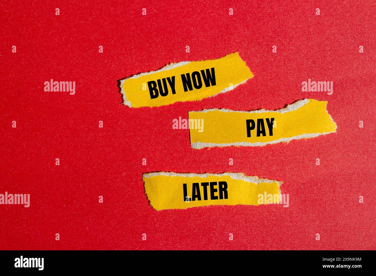 Buy now pay later words written on ripped yellow paper pieces with red ...