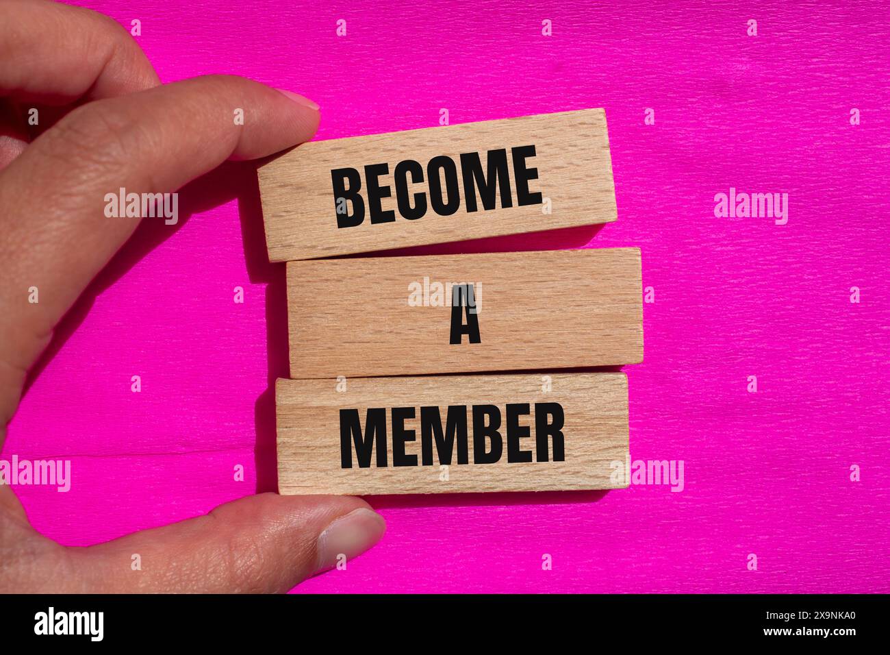 Become a member message written on wooden blocks with pink background ...