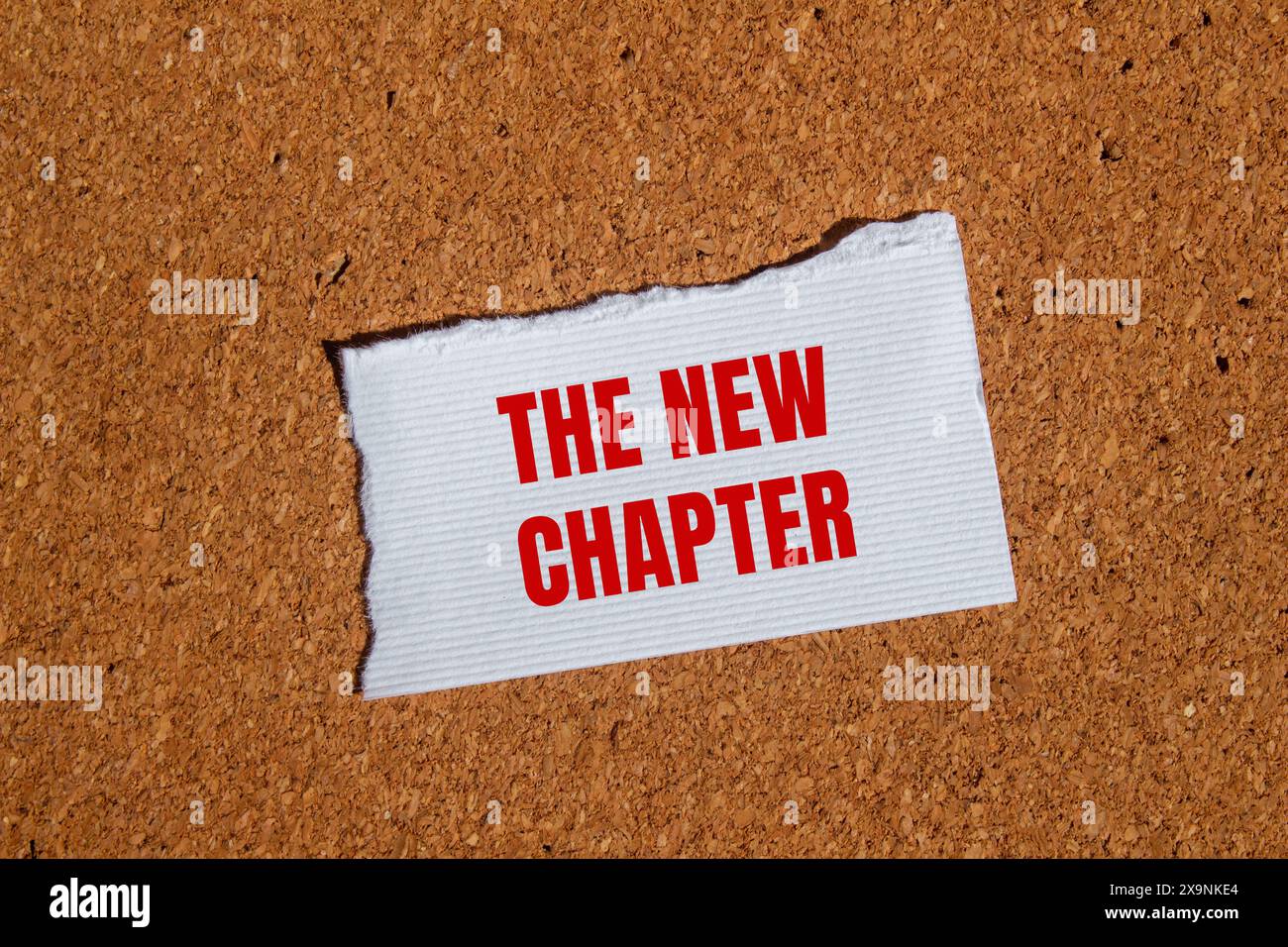 The new chapter words written on ripped white paper piece with brown ...