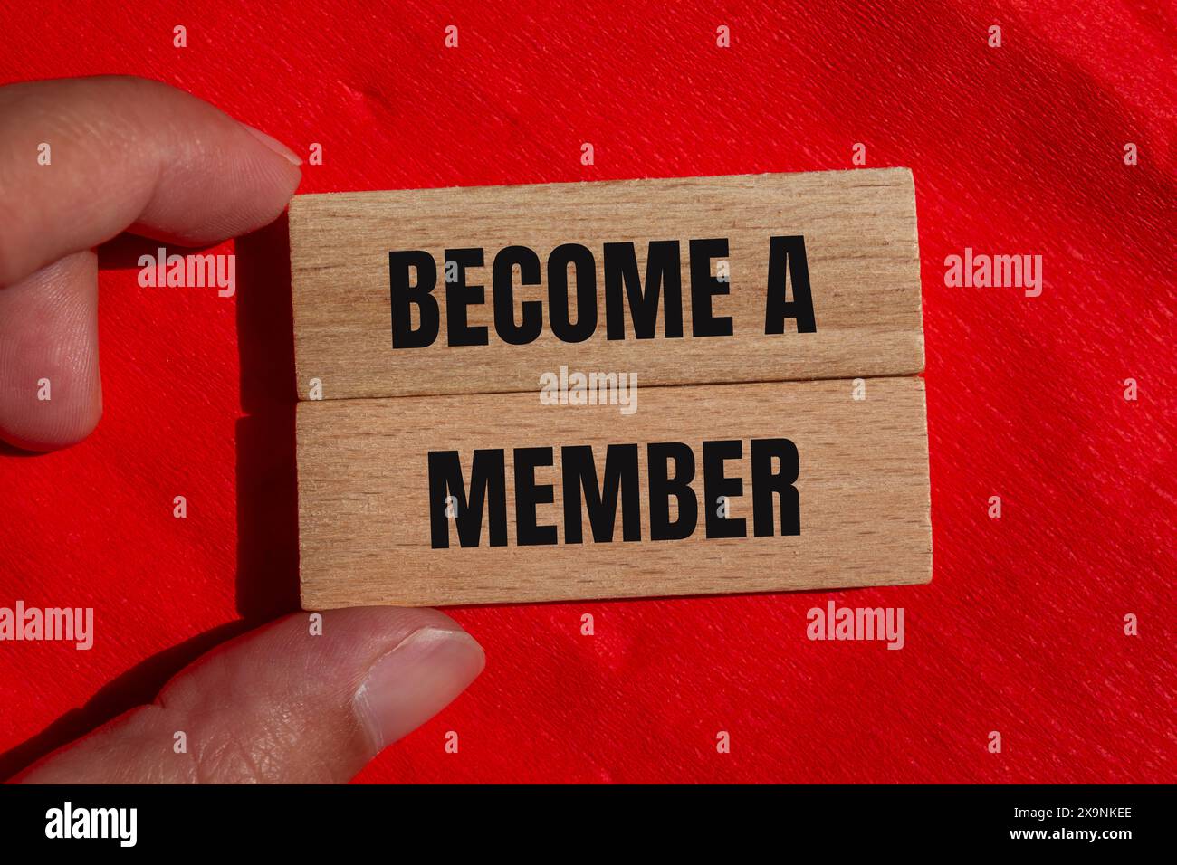 Become a member message written on wooden blocks with red background ...