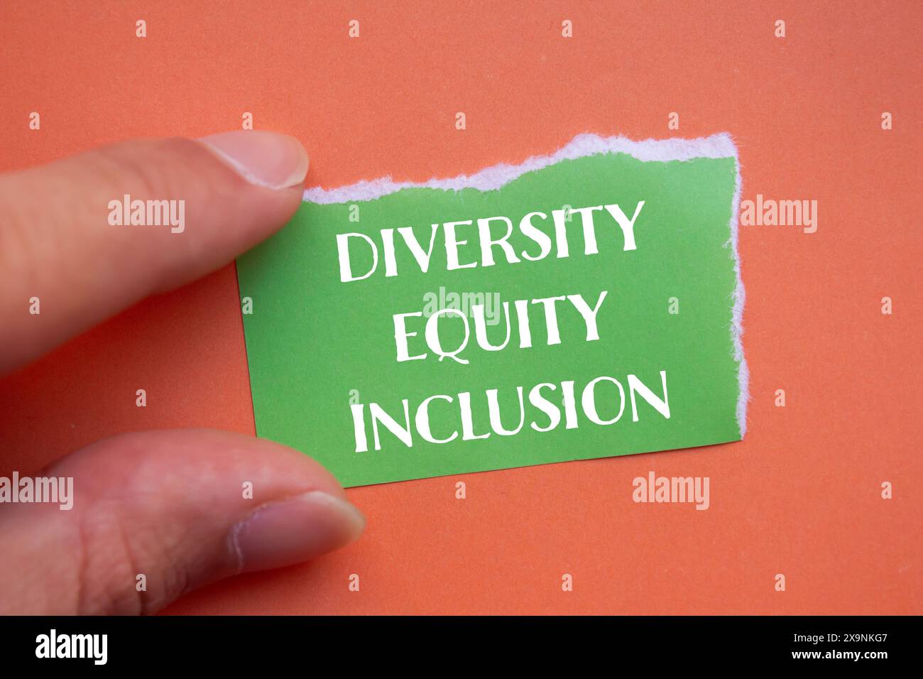 Diversity, equity and inclusion words written on ripped green paper ...