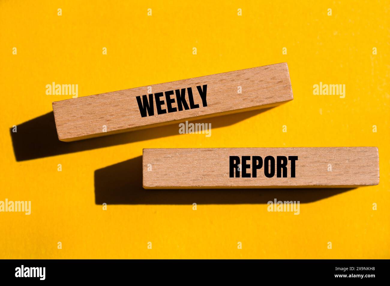Weekly report words written on wooden blocks with yellow background ...