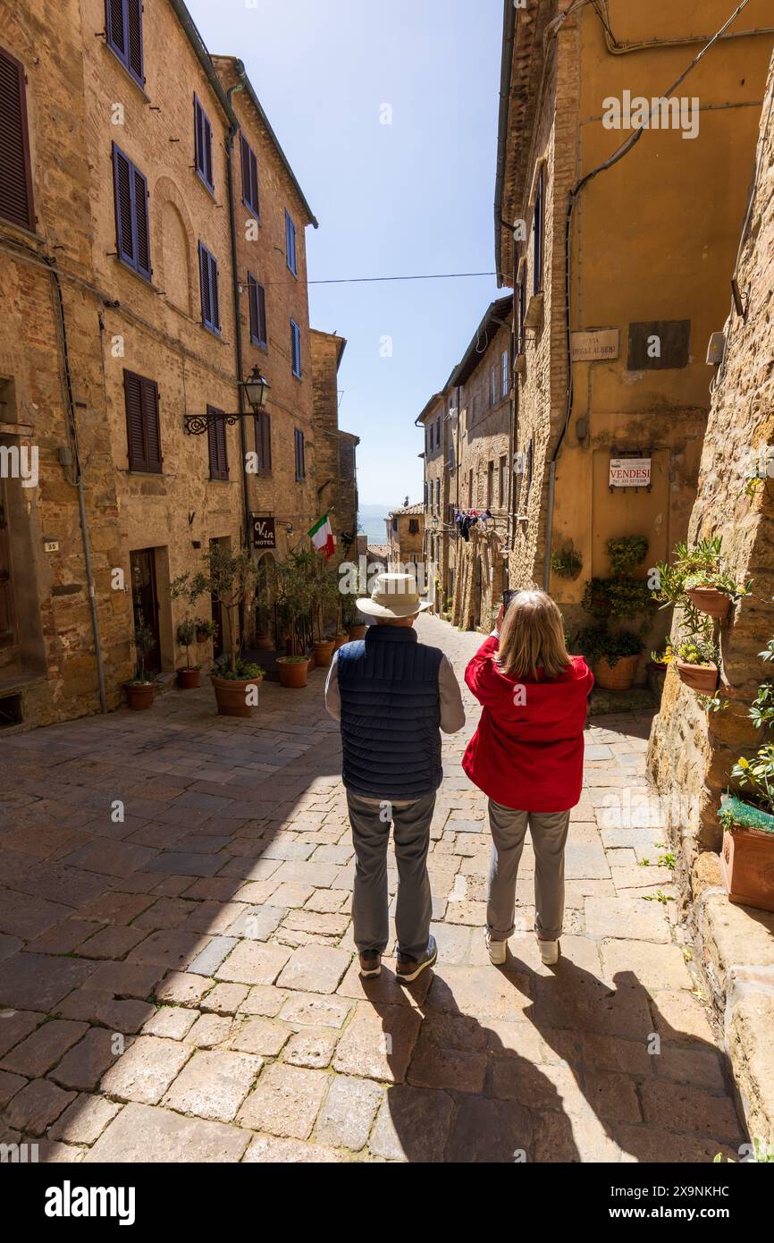 Two tourists admiring the stunning view of a beautiful narrow street in ...