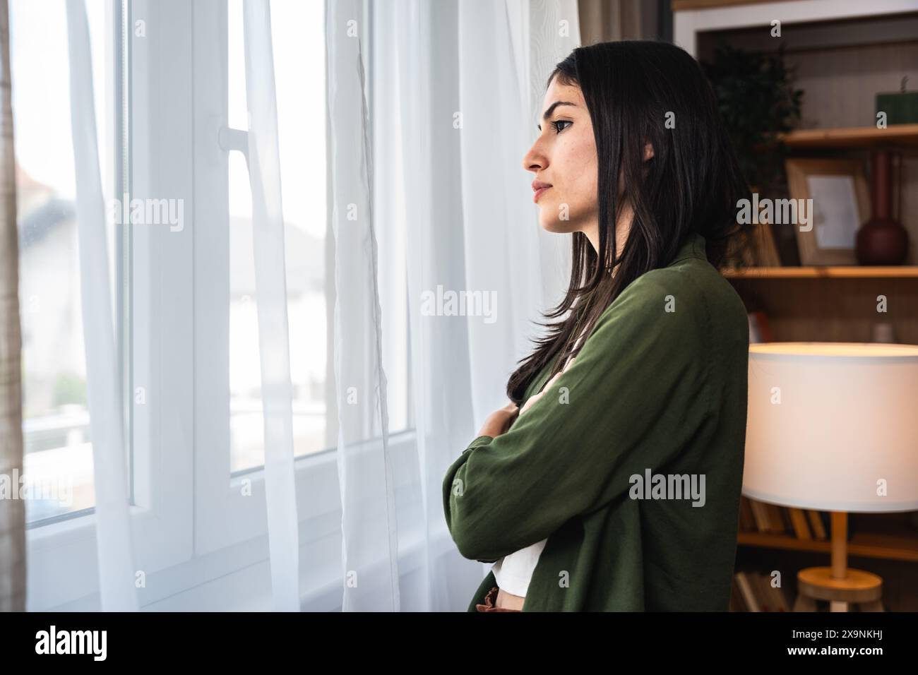 Young sad and depressed woman feeling regret and anxiety standing near ...