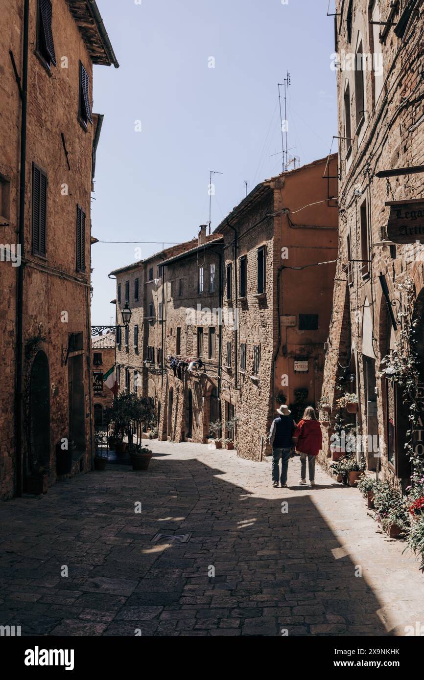 Two tourists admiring the stunning view of a beautiful narrow street in ...