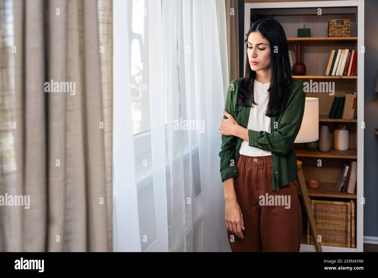 Young sad and depressed woman feeling regret and anxiety standing near ...