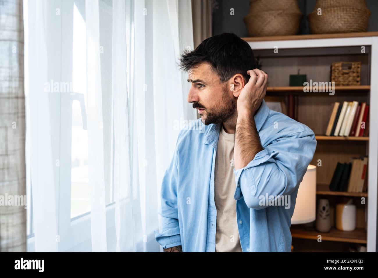 Young sad and depressed man feeling regret and anxiety, standing near ...