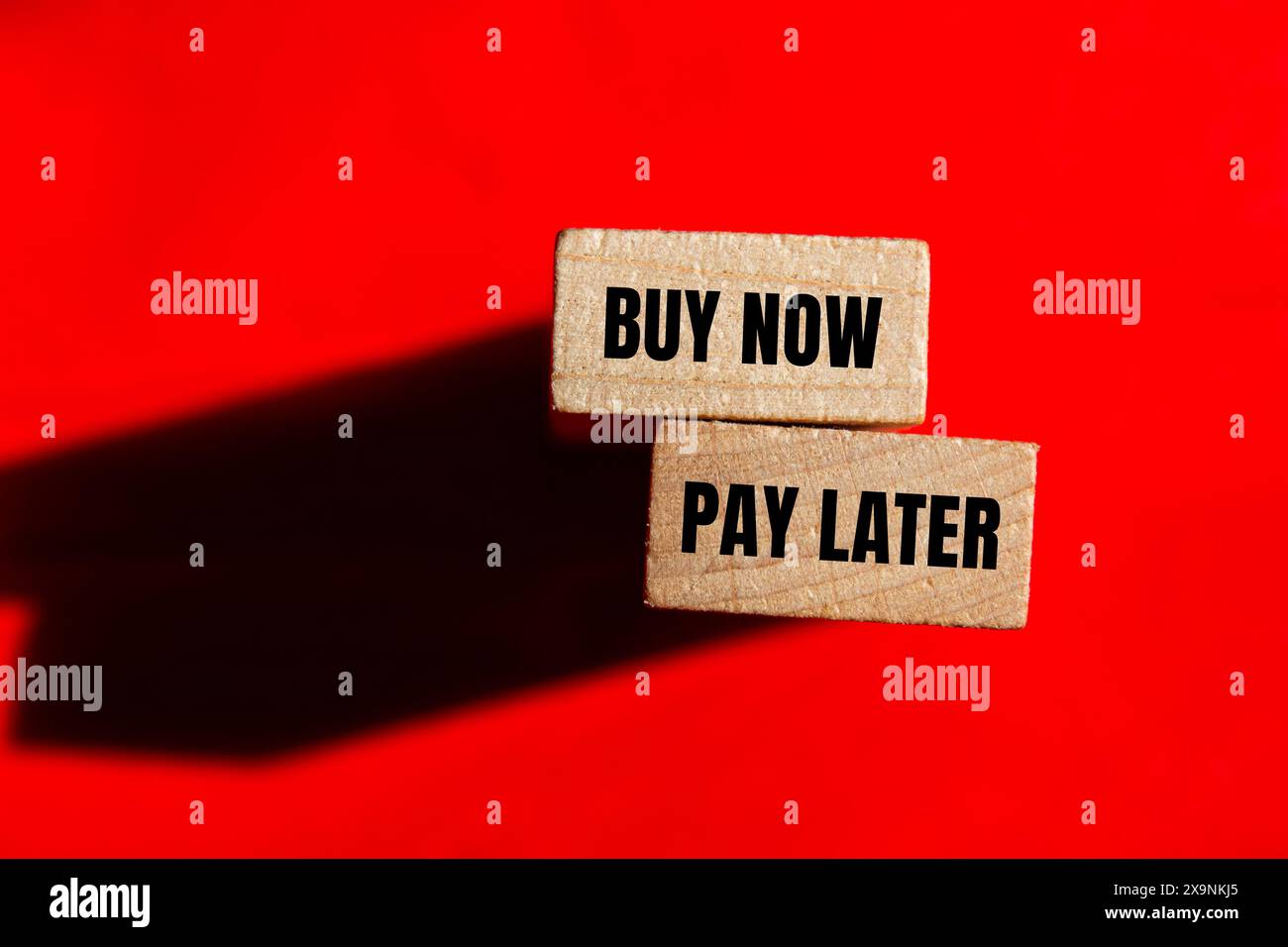 Buy now pay later words written on wooden blocks with red background ...