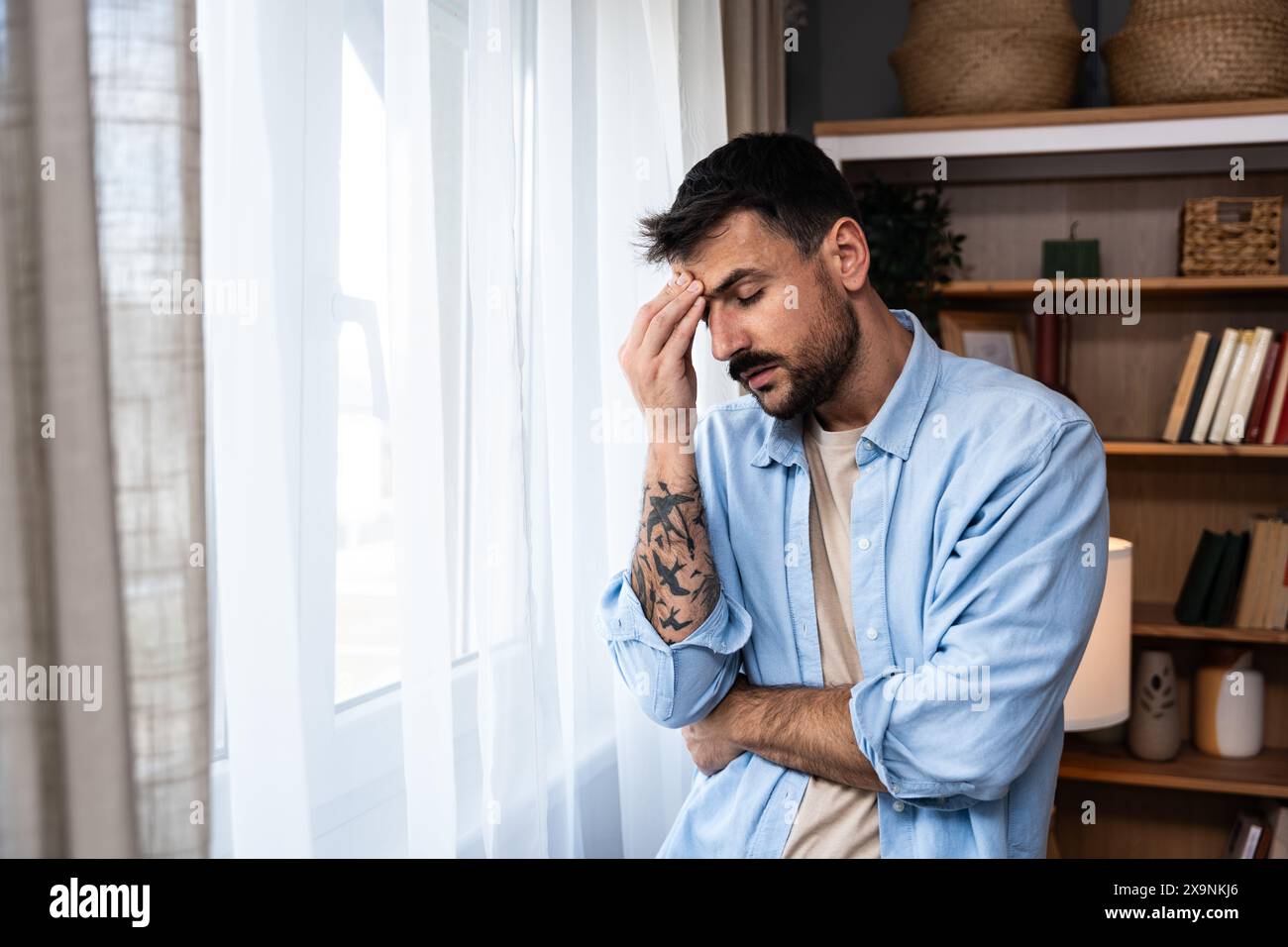 Young sad and depressed man feeling regret and anxiety, standing near ...