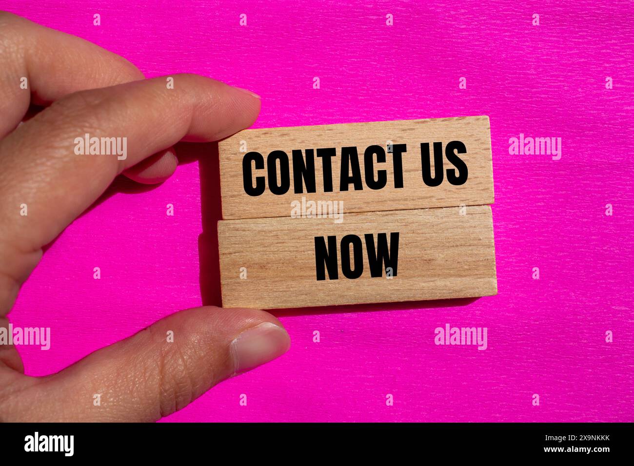Contact us now words written on wooden blocks with pink background ...