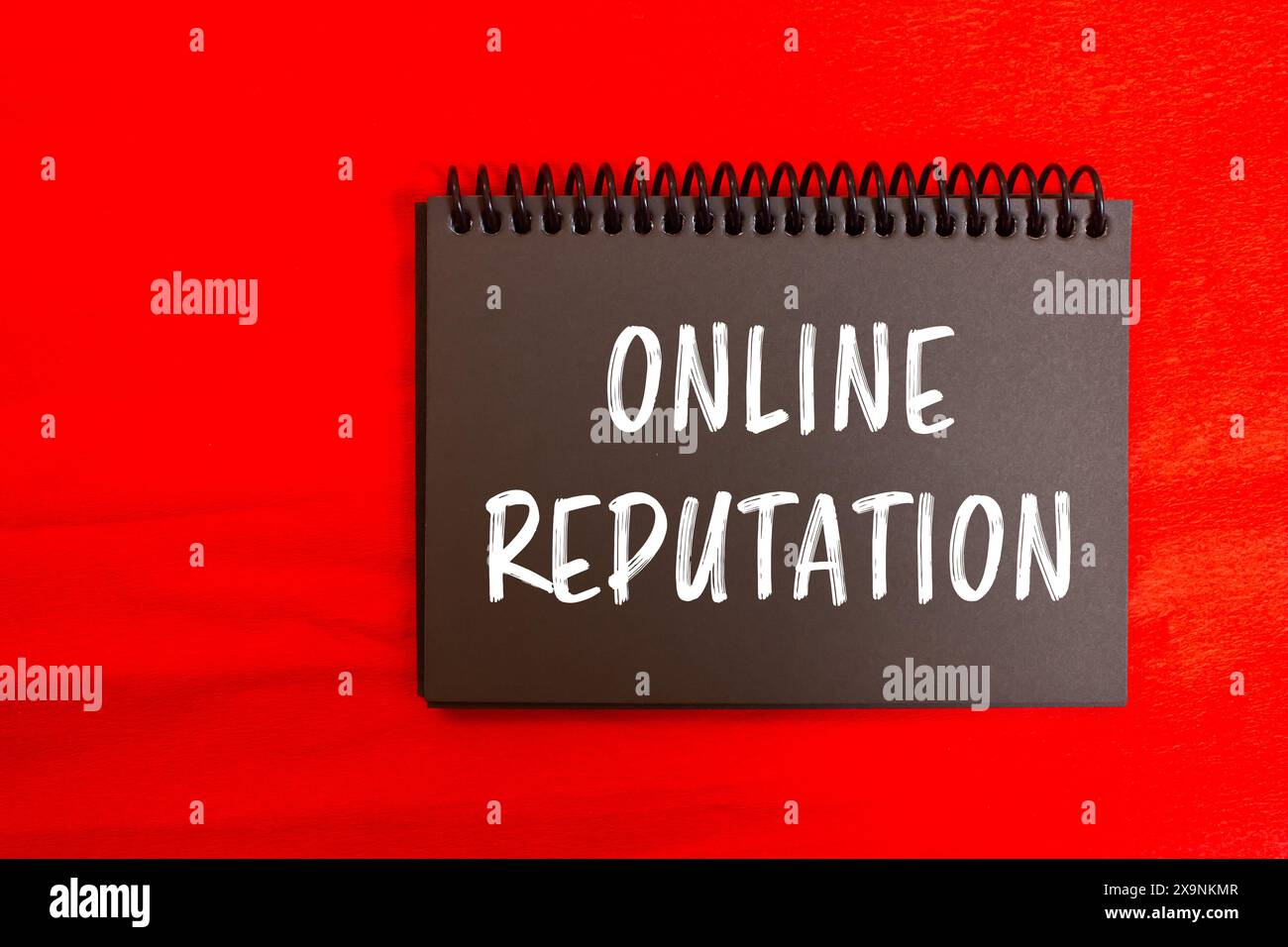 Online reputation message written on black notebook page with red ...