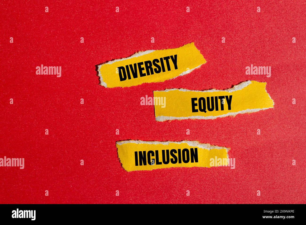 Diversity equity and inclusion words written on ripped yellow paper pieces with red background ...