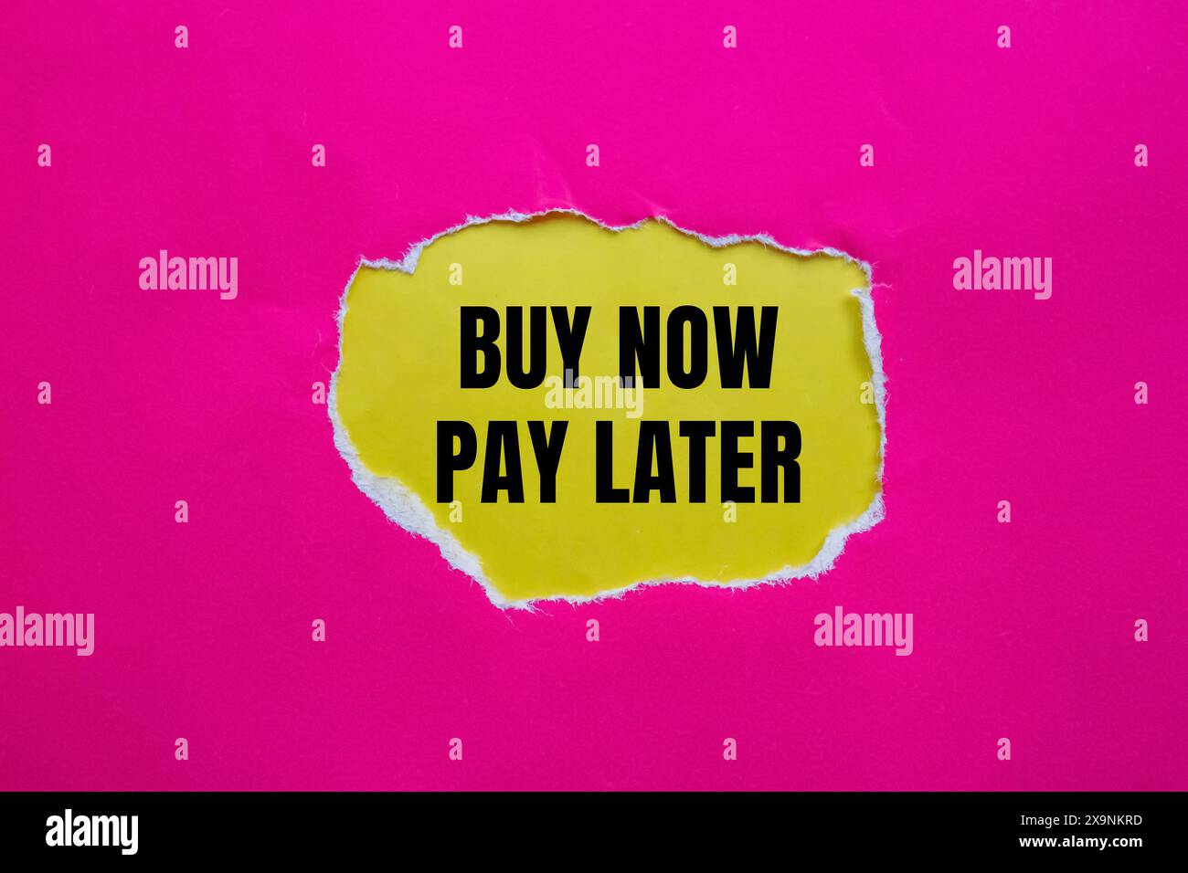 Buy now pay later words written on ripped pink paper with yellow ...