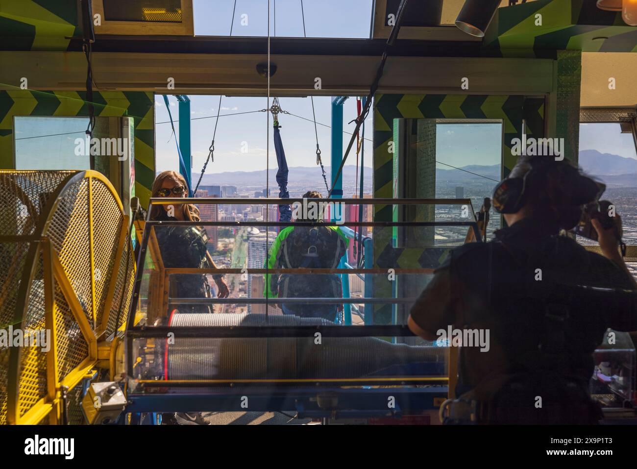 Female instructor prepares a tourist for a jump from the open Sky Pod ...