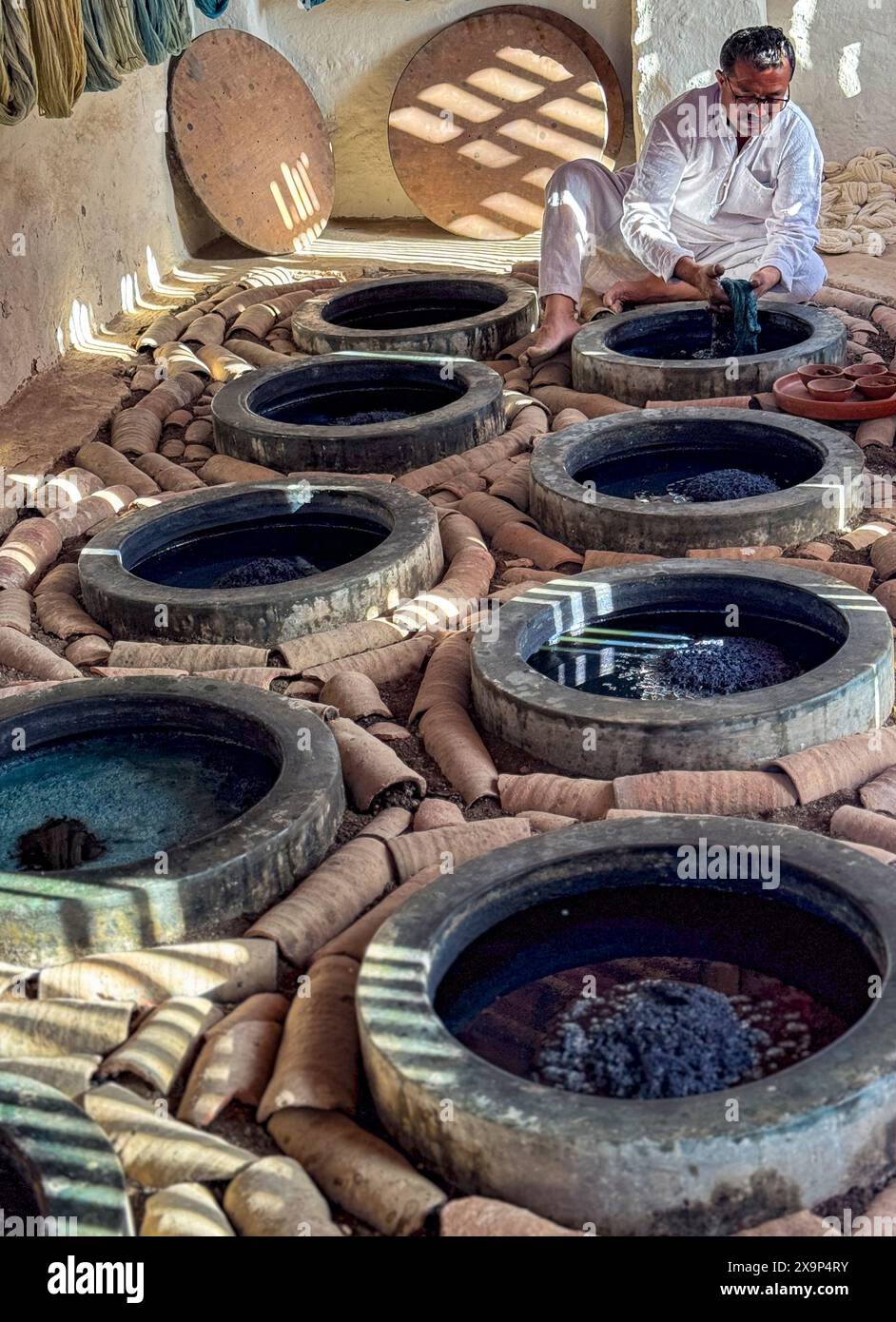 Artisan prepares dye in vats at an old dye workshop, showcasing ...