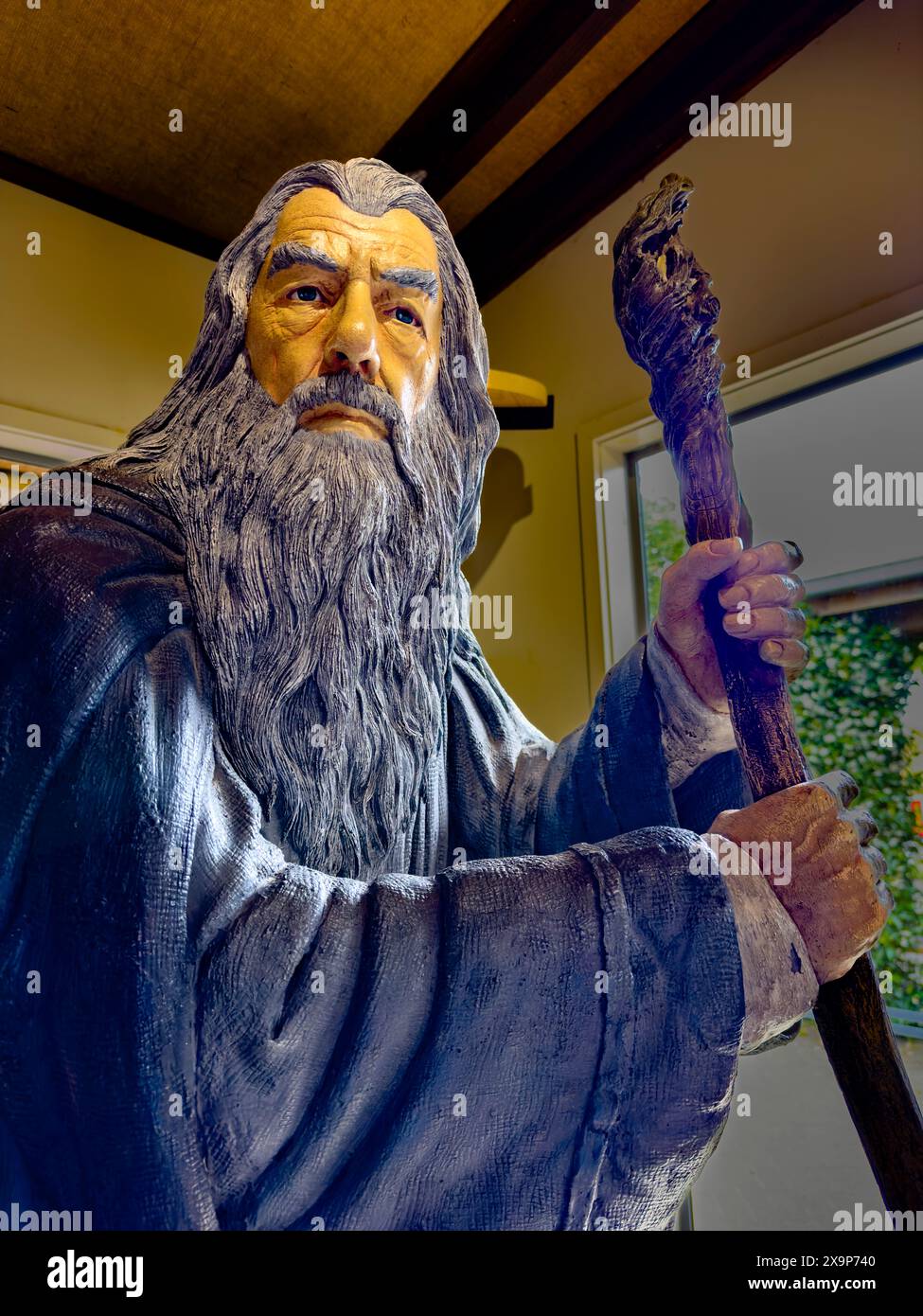 Lifelike statue of a bearded wizard holding a staff with a thoughtful ...