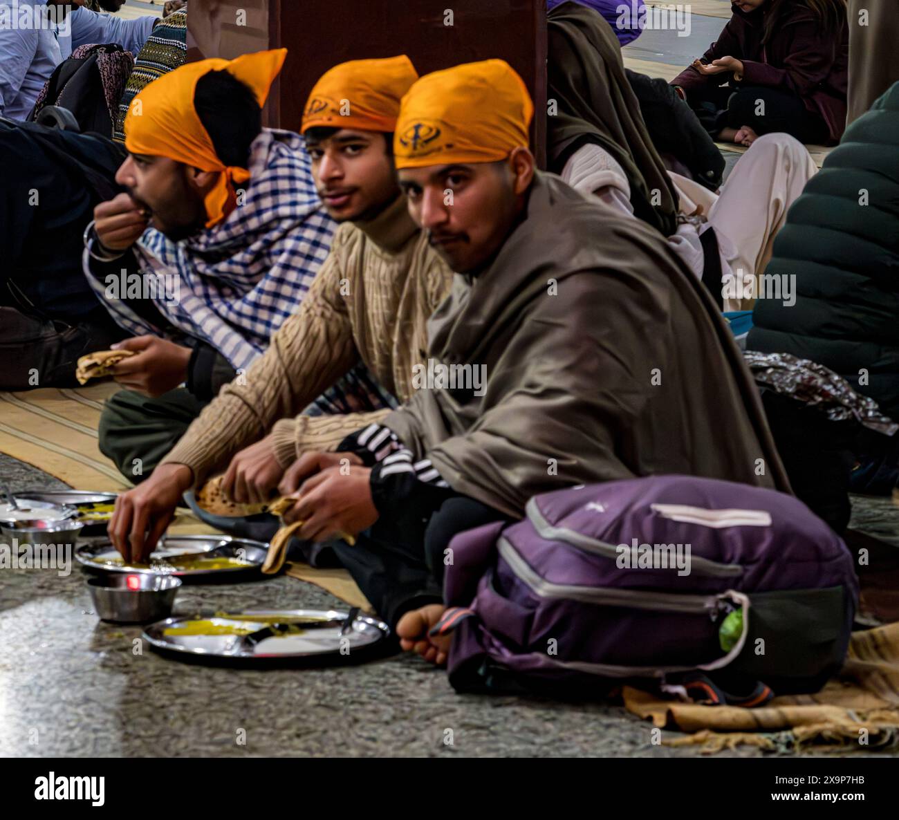 Group of young sikh men sharing a meal in a community kitchen at a ...