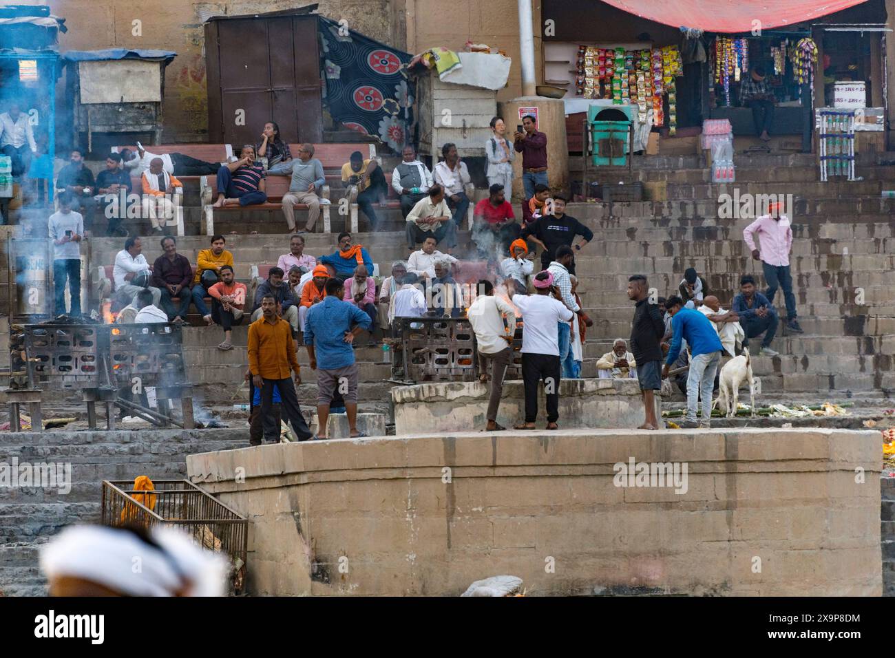 Active scene at riverside ghats, with crowds engaged in various rituals ...