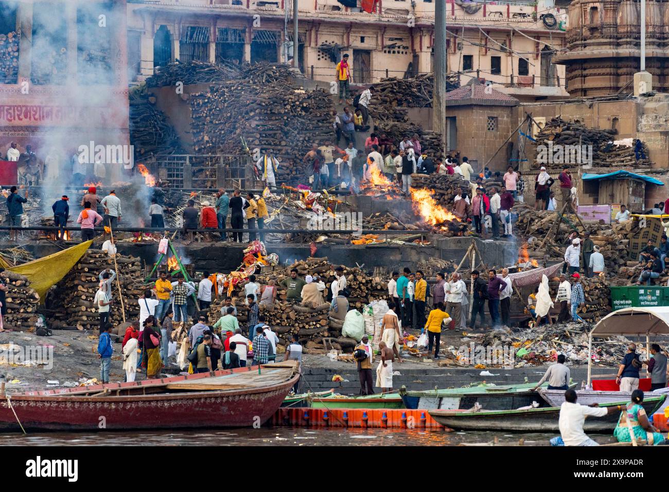 People gather for a ritual funeral pyre cremation along the sacred ...