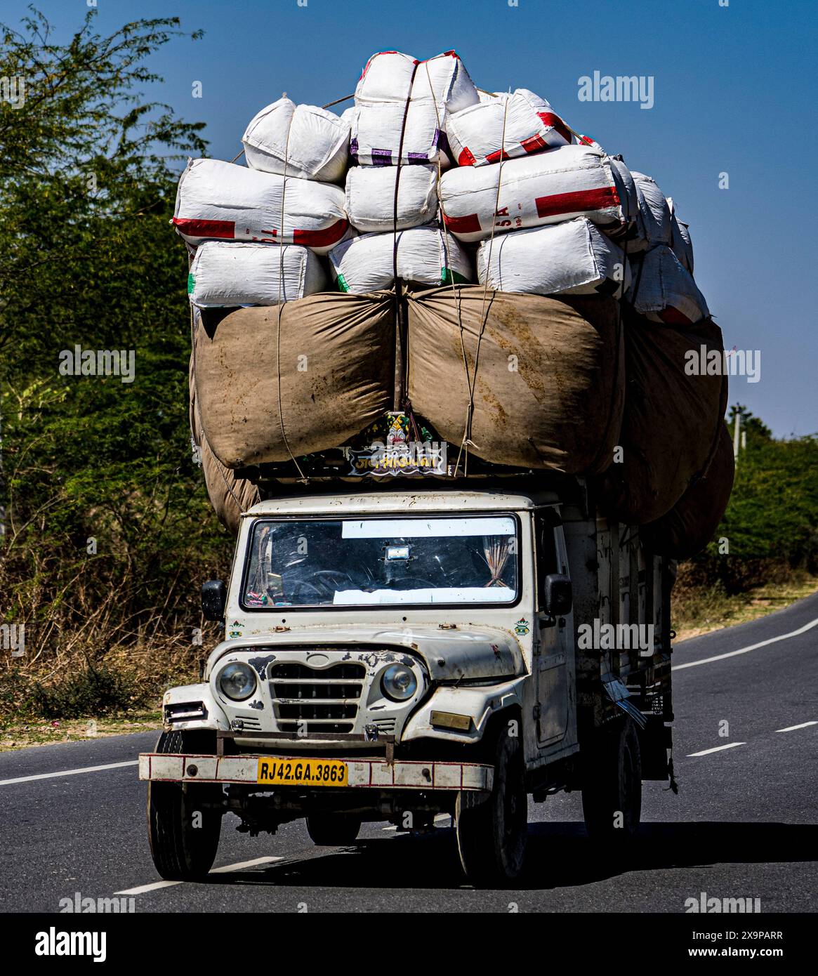 Overburdened truck travels on a highway, illustrating transportation ...