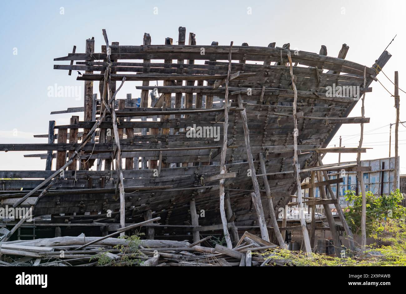 Abandoned ship structure with weathered beams and barren landscape ...
