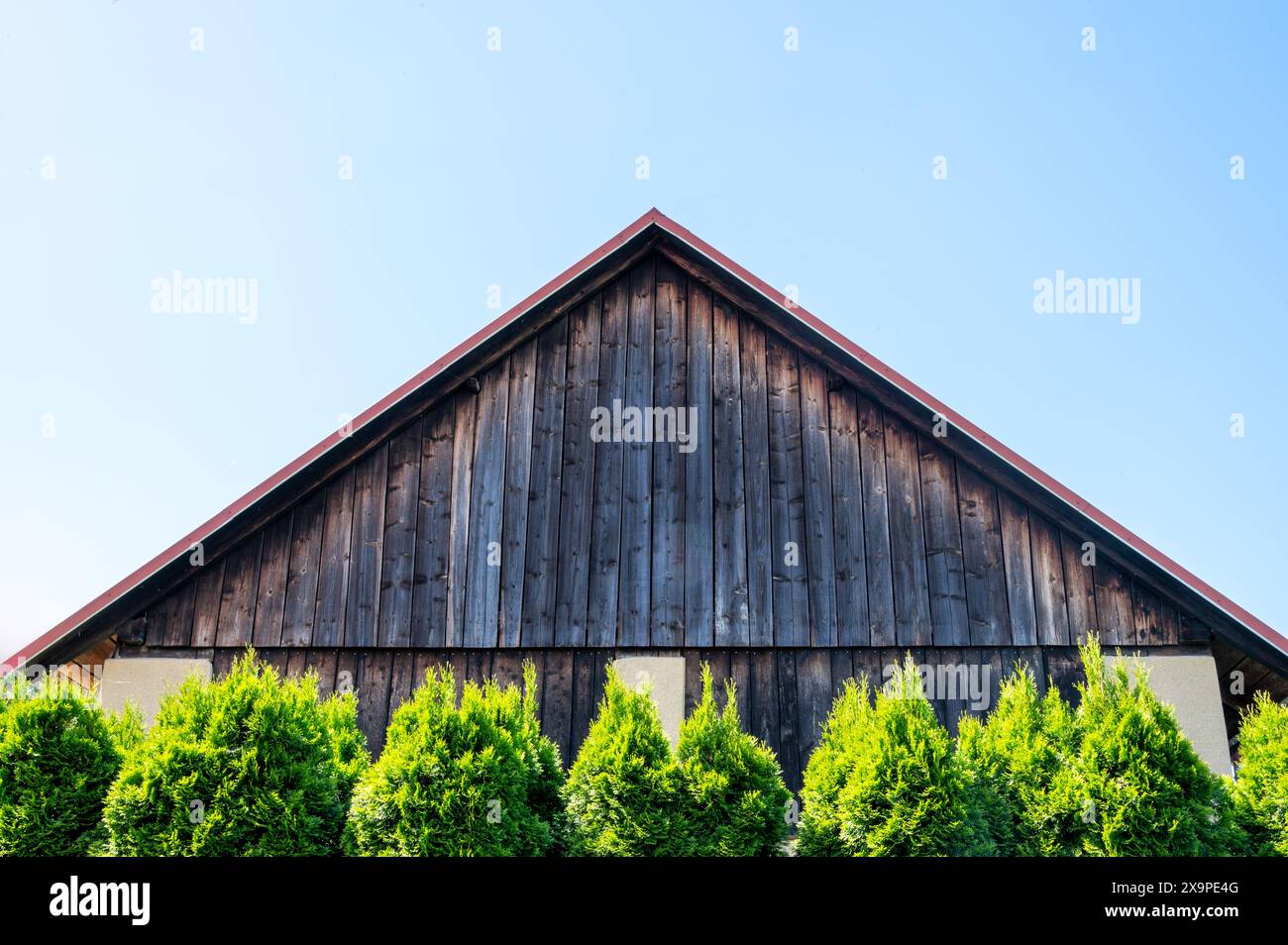 A vivid portrayal of a rustic wooden barn's top facade, accented by ...