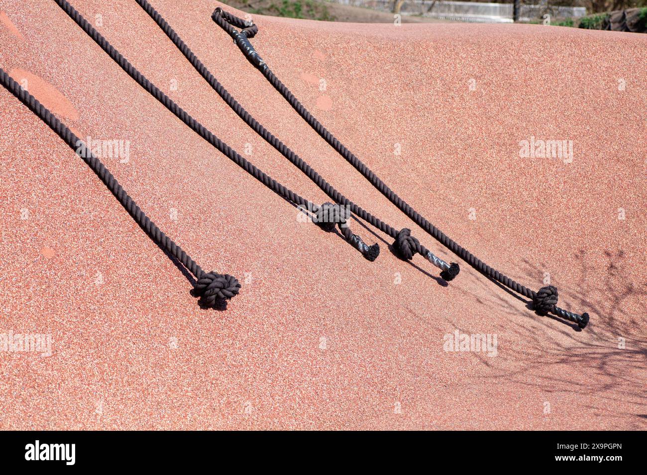 Climbing ropes with handles on a playground structure in bright ...