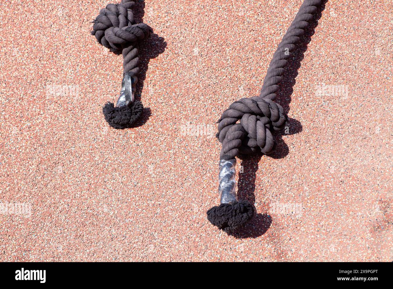Ropes with handles on a climbing structure in a playground under bright ...