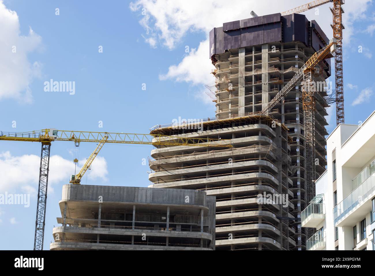 A tall skyscraper being built with a clear blue sky in the backdrop ...
