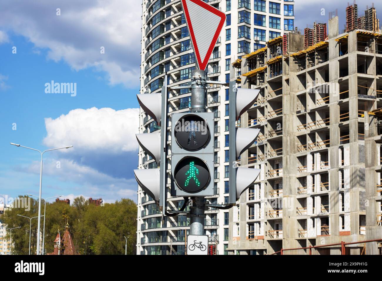 In front of a building under construction, a traffic light displays a ...