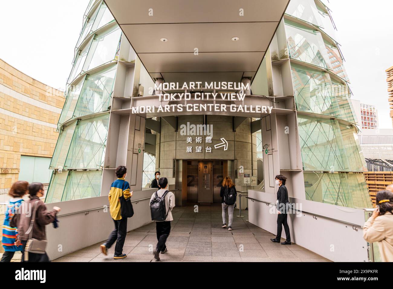 People walking to and entering the Mori Art Museum and Tokyo City view entrance at the Roppongi ...