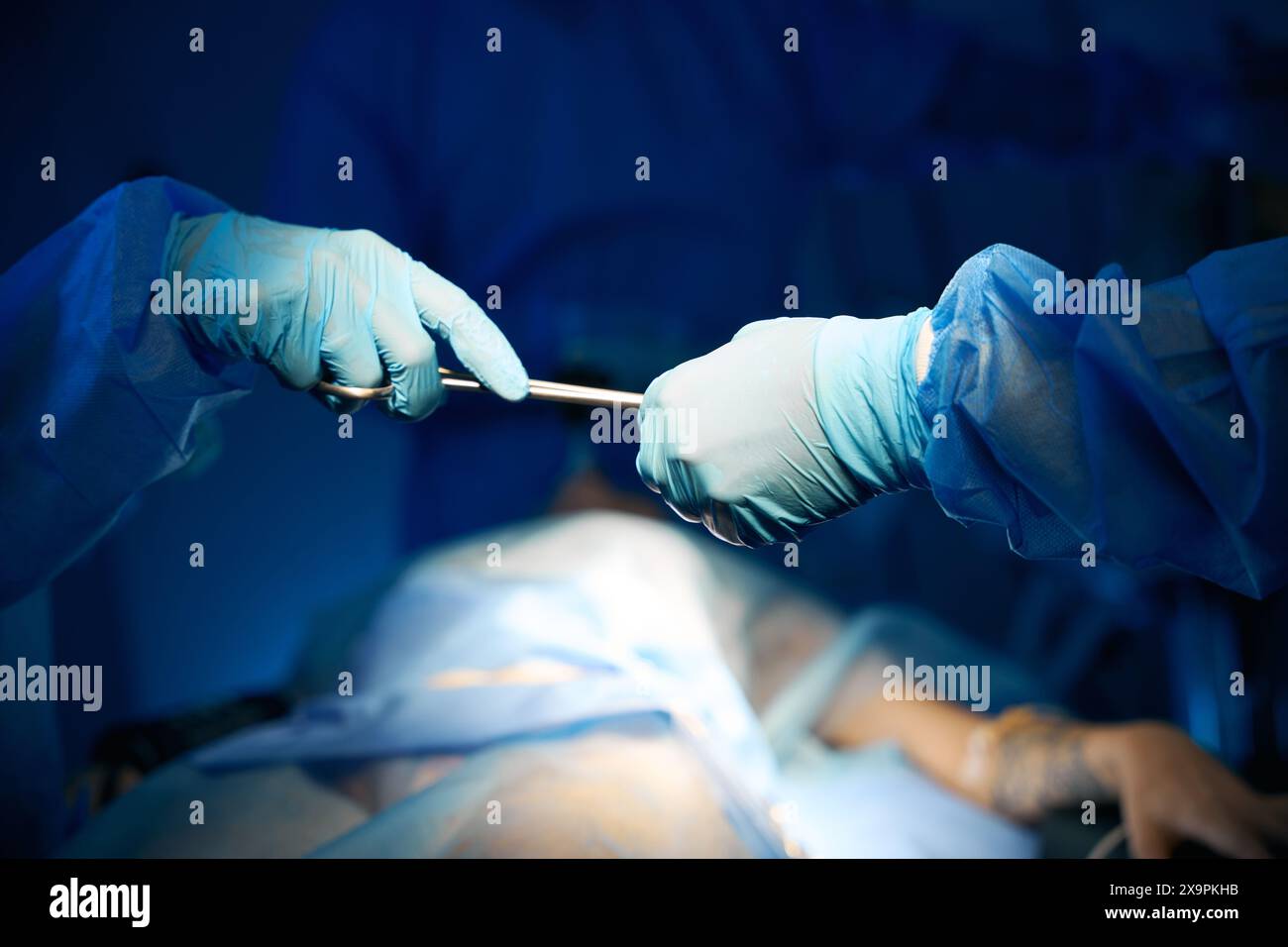 Nurse giving sterile scissors to surgeon during operation Stock Photo ...