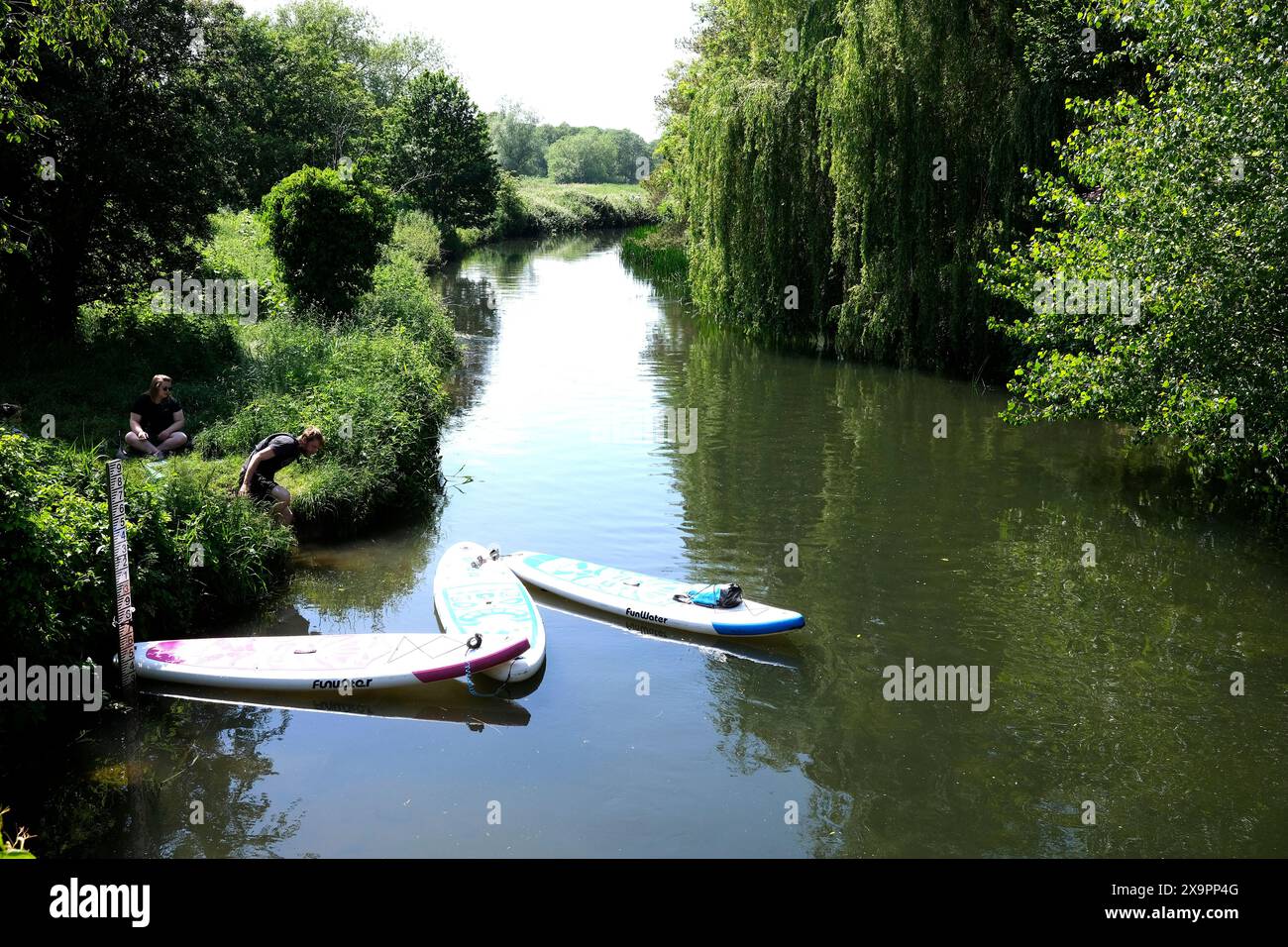 river stour in fordwich village showing canoes with men sitting on the ...