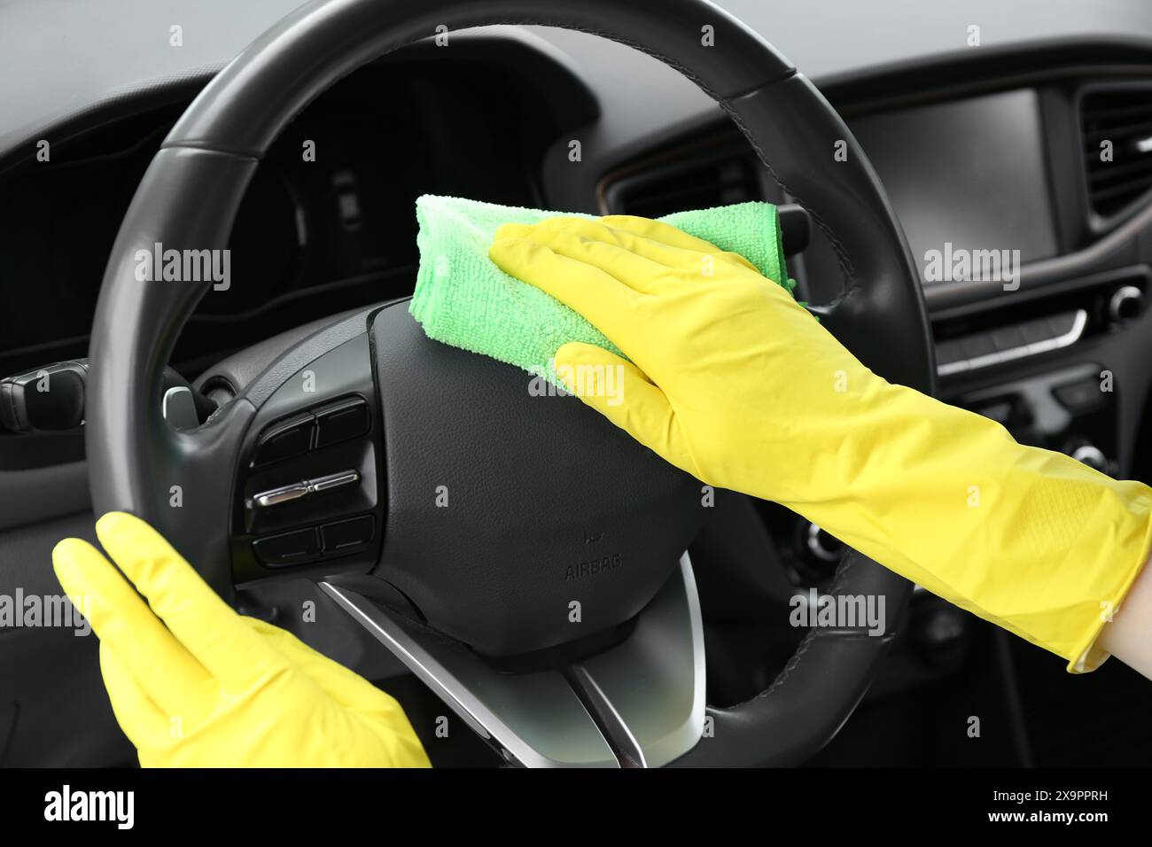 Woman cleaning steering wheel with rag in car, closeup Stock Photo - Alamy
