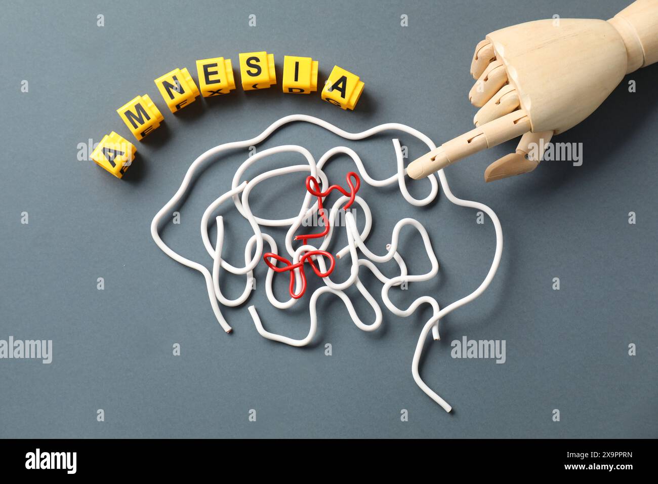Word Amnesia, brain made of wires and mannequin hand on grey background ...