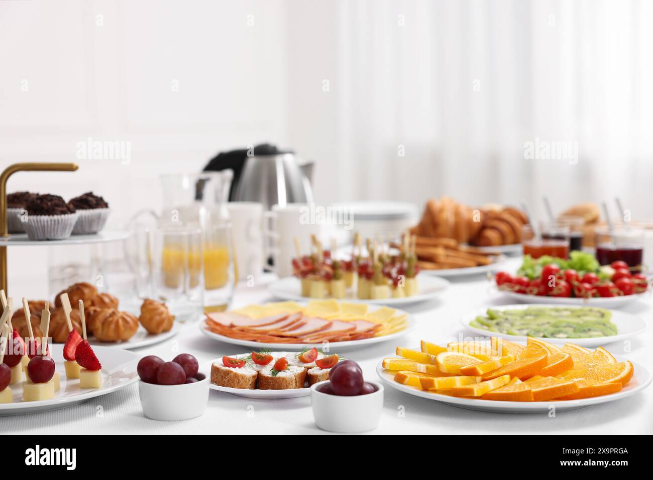 Different meals served on white table indoors. Buffet menu Stock Photo ...