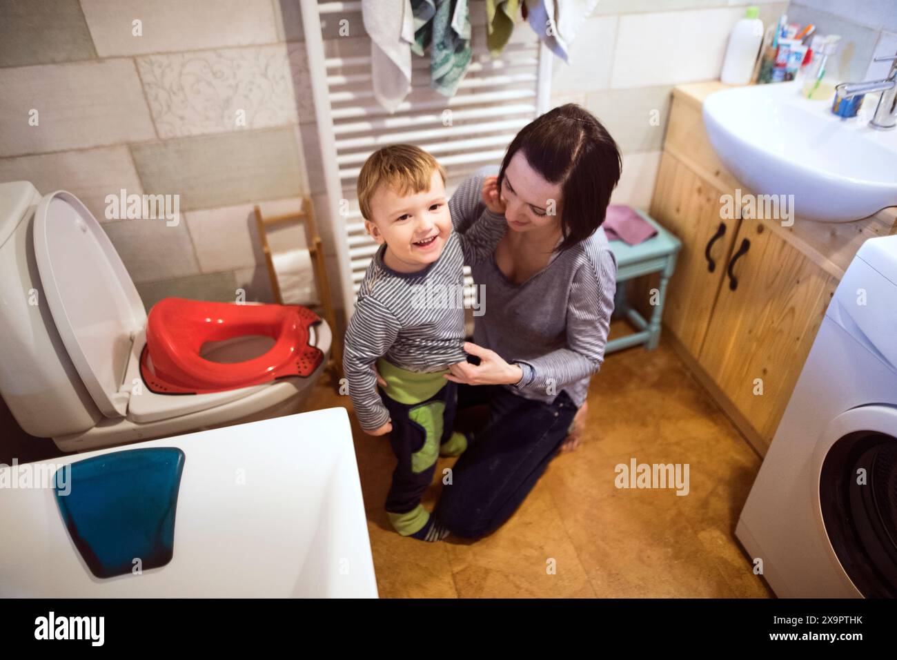 Mom is helping toddler boy use the toilet. Potty-trained little boy in ...